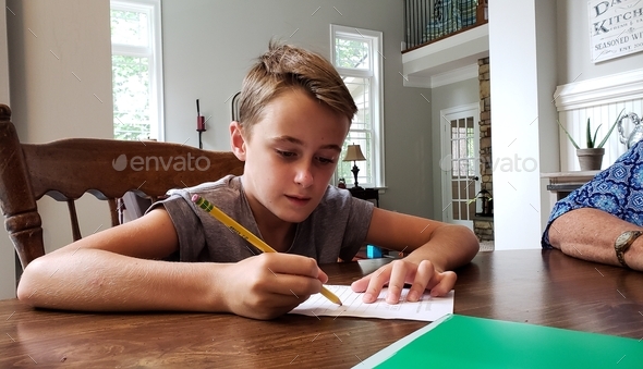 Generation z little boy doing school work with help from grandparents ...