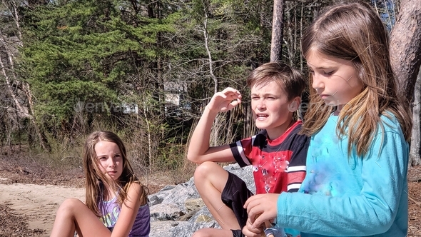 Generation z siblings sitting on rocks hanging out and having fun ...
