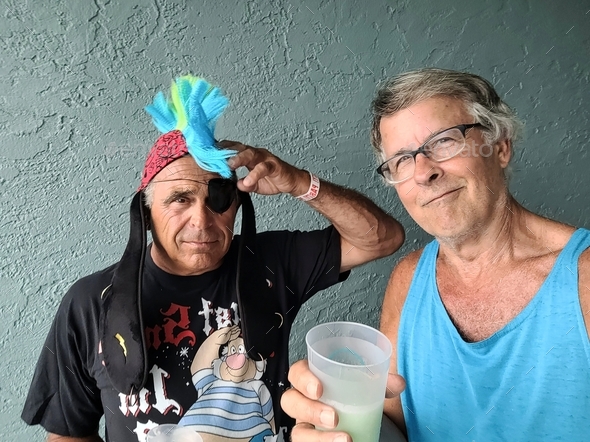 Active baby boomer friends taking a happy selfie at a costume party on ...