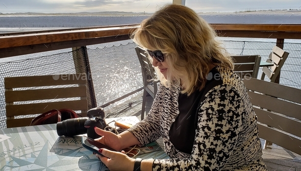 Business professional baby boomer on vacation with cell phone in hands ...