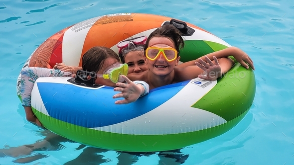 Generation z siblings in a pool on a round float having fun together on ...
