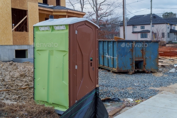 Portable restroom on a dumpsters being full with garbage house under ...