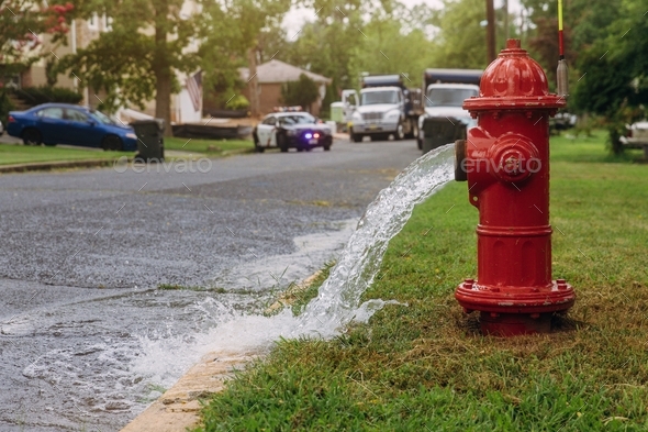 Water flowing from in open red fire hydrant is wet from the spray ...