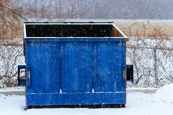 Trash bin at the side of street in winter with lip garbage container ...