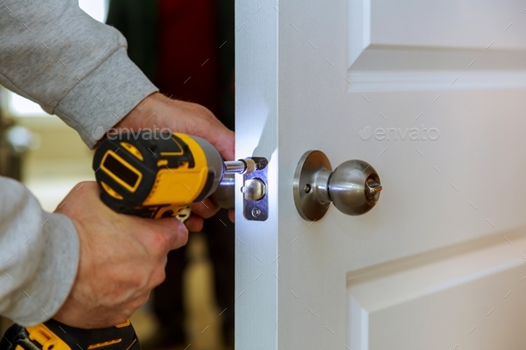 Carpenter Install Door Lock Using Screwdriver At Home installation of ...