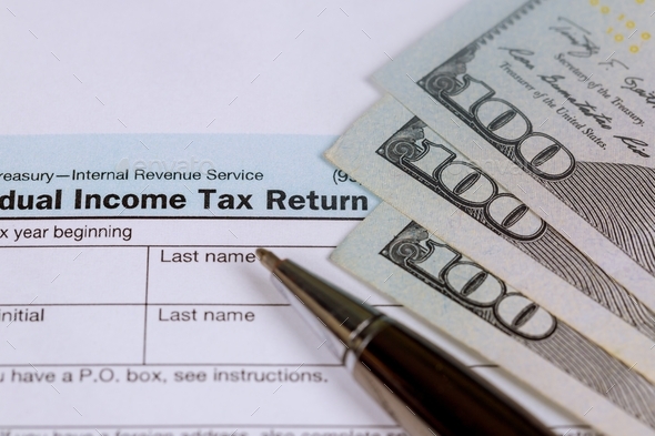 Economic stimulus tax 1040 form and US 100 dollar bills currency Stock ...