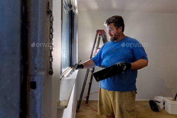 Handyman paints a window molding frame with a paint brush Stock Photo ...
