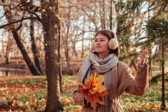 Cute teenage girl in fall park with autumn leaves Stock Photo by AlexVog