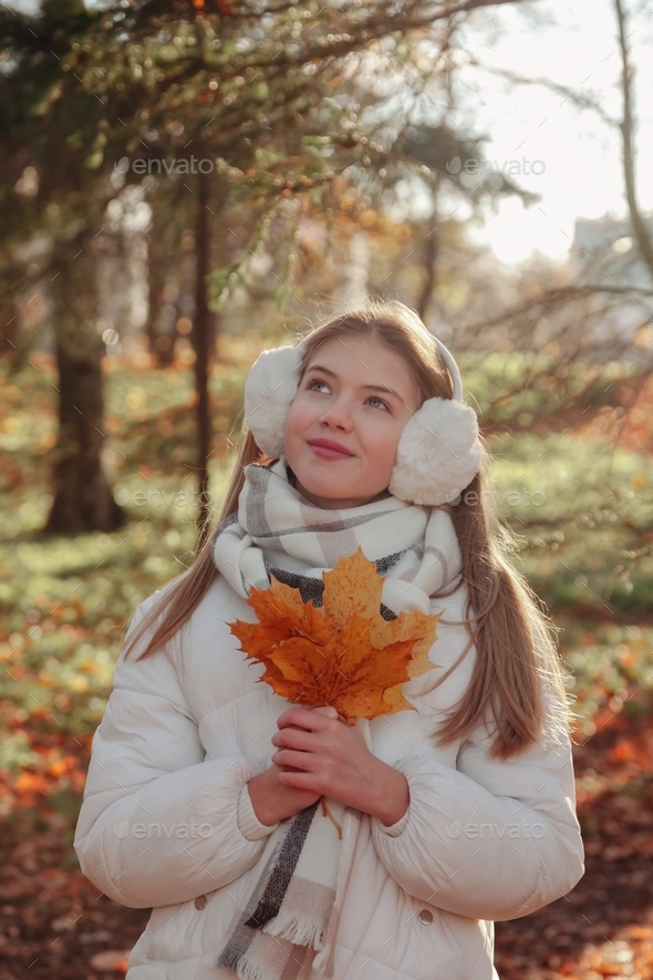 Cute teenage girl in fall park with autumn leaves Stock Photo by AlexVog