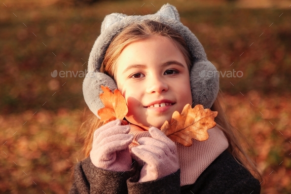 Cute little girl in fall park with autumn leaves Stock Photo by AlexVog