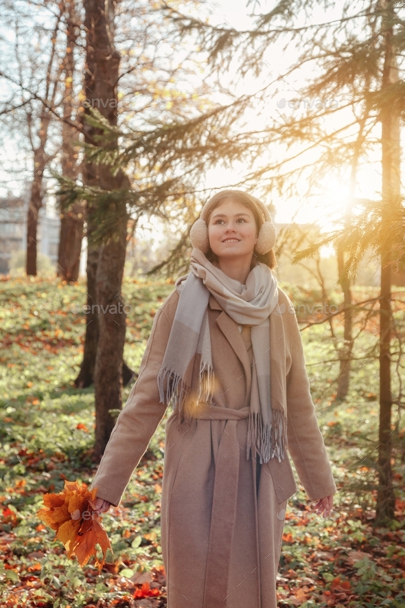 Cute teenage girl in fall park with autumn leaves Stock Photo by AlexVog