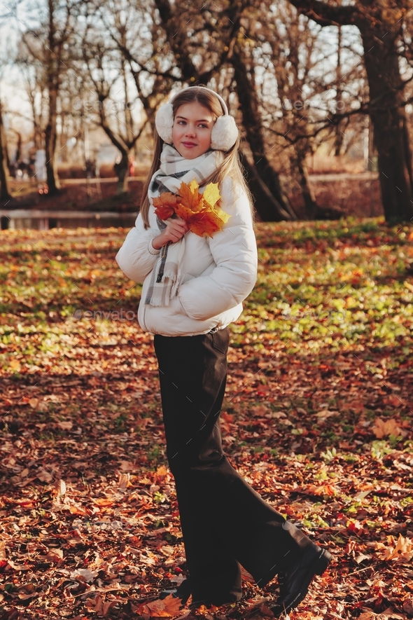 Cute teenage girl in fall park with autumn leaves Stock Photo by AlexVog