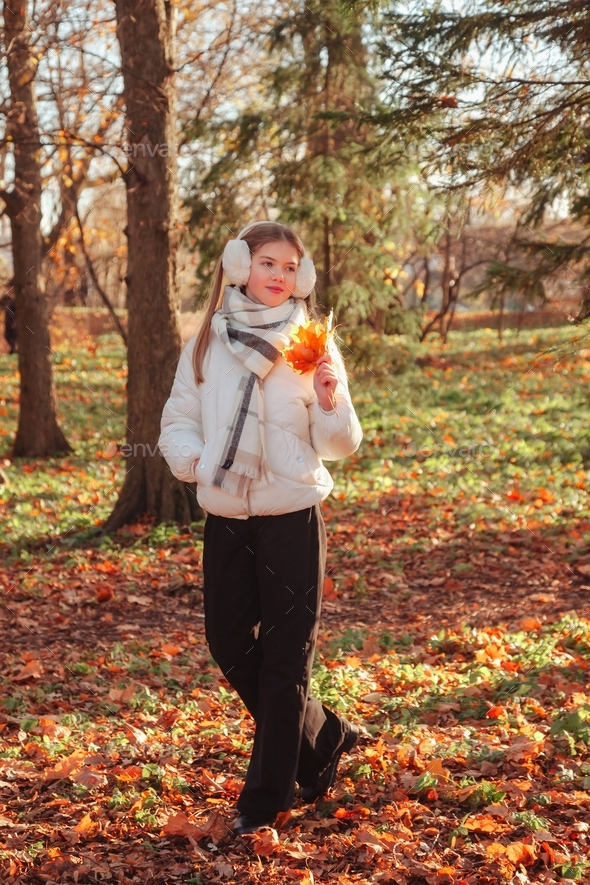 Cute teenage girl in fall park with autumn leaves Stock Photo by AlexVog