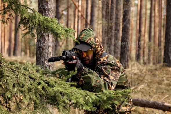A military border guard in camouflage uniform and disguise with a ...