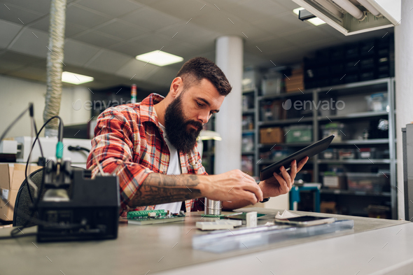 Electronics engineer working in a workshop with tin soldering parts and ...