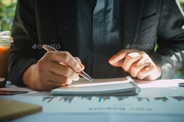 Man writing in a notebook. Write down important business data ...