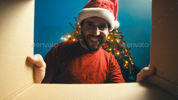 Boy is closing the Christmas gift box under the tree Stock Photo by ...