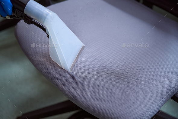 Janitor performing the cleaning of the chairs with special vacuum ...