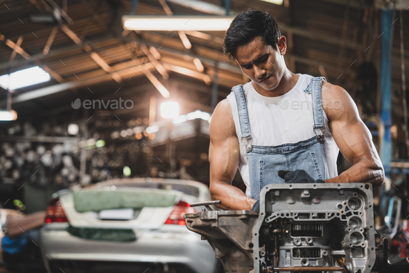 Handsome young male mechanic and car repair service man using various ...