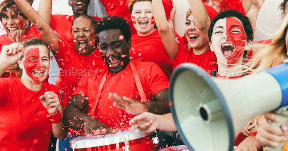 Multiracial red sport fans screaming while supporting their team ...