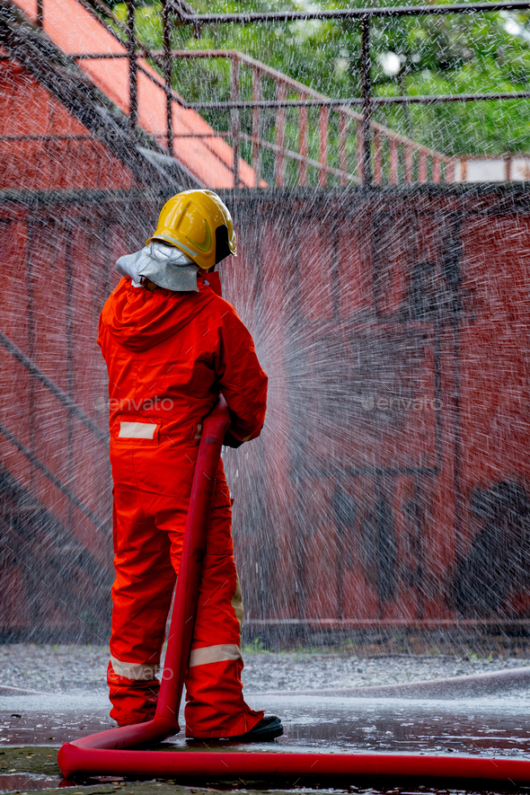 Firefighter man practice to use sprinkler to splash as circular and ...