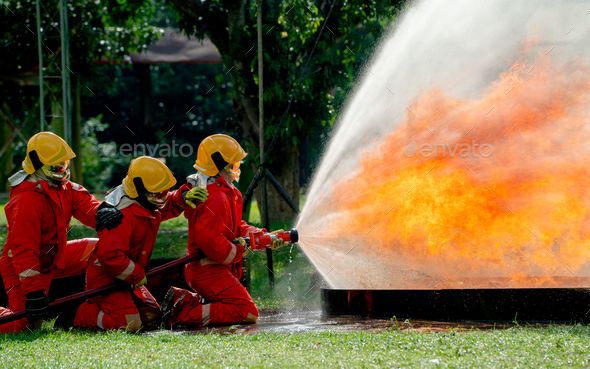 Three of firefighters support to use sprinkler to create water curtain ...
