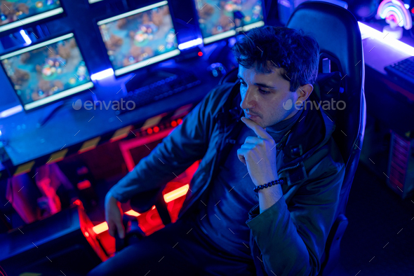 Gamer man sit with relax and touch finger on his chin look like feel ...