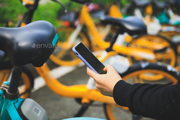 Hand using smartphone scanning the QR code of shared bike in city Stock ...