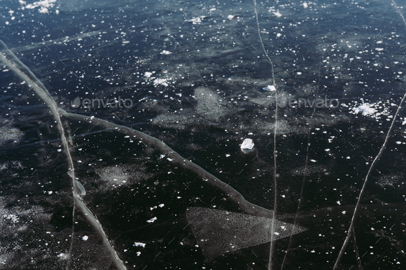Top-down aerial view of winter frozen texture of ice lakes with cracks ...