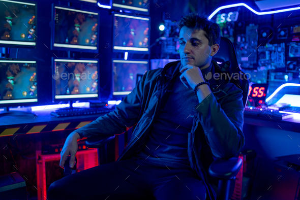 Gamer man sit with relax and touch finger on his chin look like feel ...