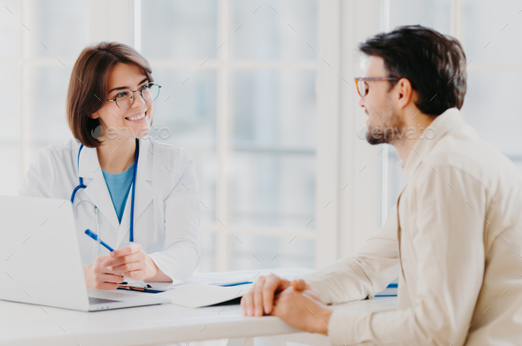 Attentive female doctor explains diagnosis to patient, gives ...