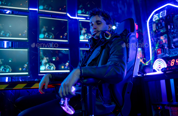 Smart man sit on chair and look at camera also stay in room with ...