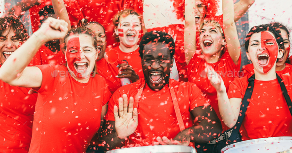 Multiracial red sport fans screaming while supporting their team ...