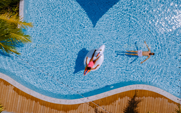 View from above at a swimming pool, couple men and women in swimming ...