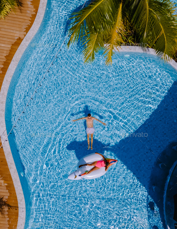 View from above at a swimming pool, couple men and women in swimming ...
