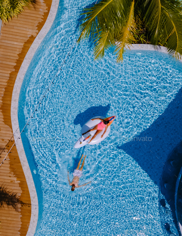 View from above at a swimming pool, couple men and women in swimming ...