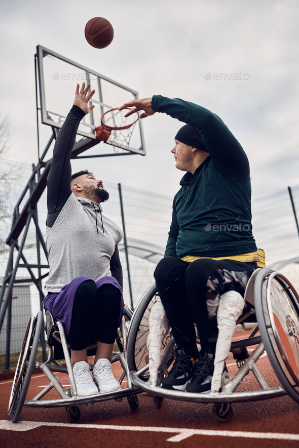 Wheelchair-bound basketball player shooting at the hoop during the game ...