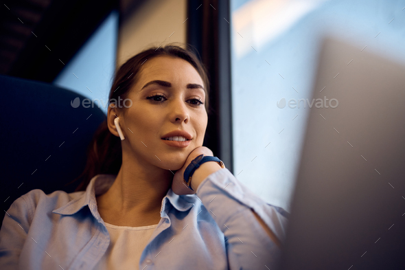 Young woman reading an e-mail on laptop while commuting by train. Stock ...