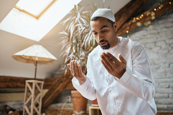 Man of Islam faith reciting dua while praying at home. Stock Photo by ...