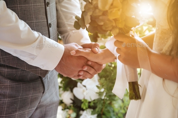 Close-up hands of fiancee (bride) and groom during wedding registration ...