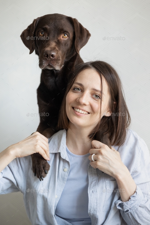 adorable chocolate Labrador retriever and beautiful Caucasian woman ...