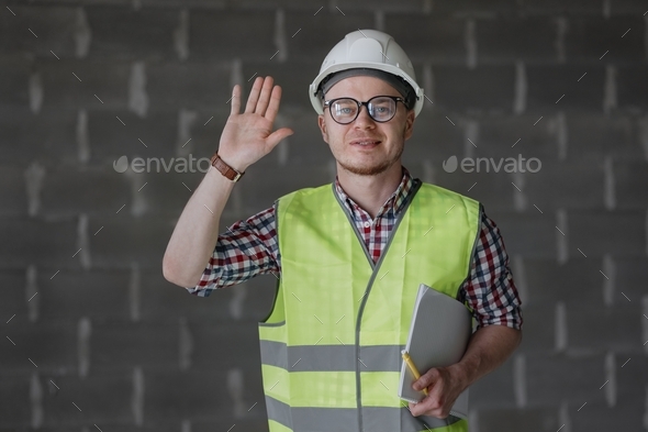 portrait engineer man in a white construction helmet and safety vest ...