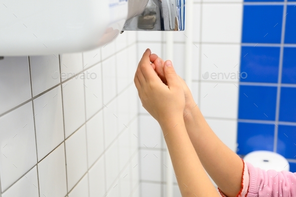 child hands using air dryer in public toilet or washrooms Stock Photo ...