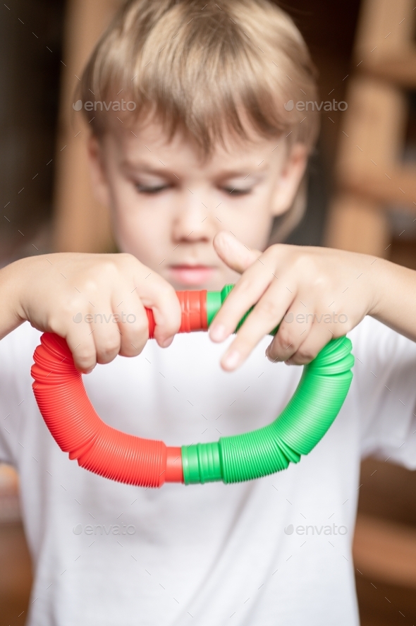 anti stress sensory pop tube fidget toy in kid's hands. little happy ...