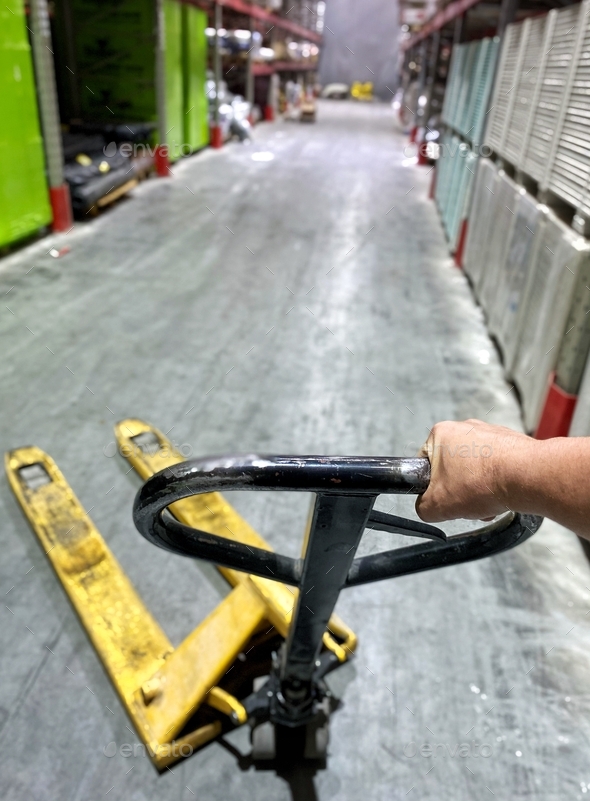 order picker pulling pallet truck between racks in warehouse Stock ...