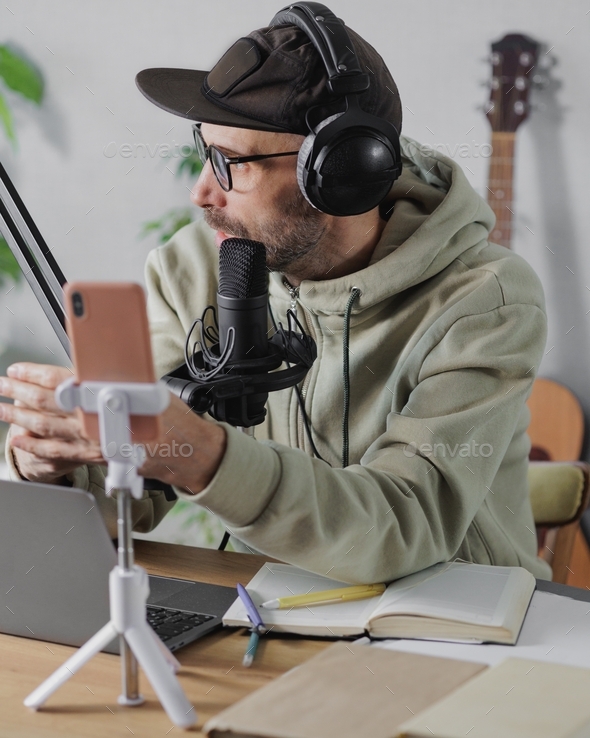 European man in a baseball cap and glasses is a radio host with a ...
