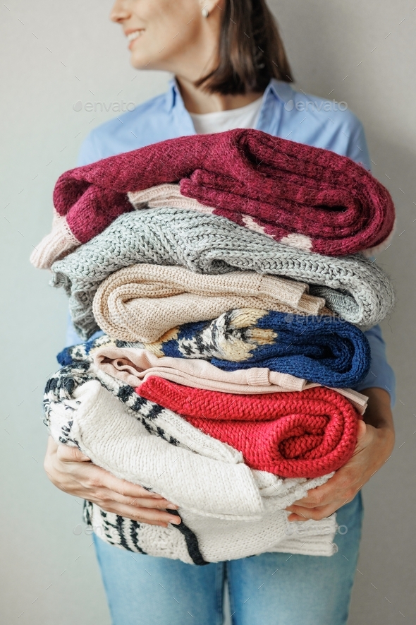 European woman takes apart clothes for washing or dry cleaning laundry ...
