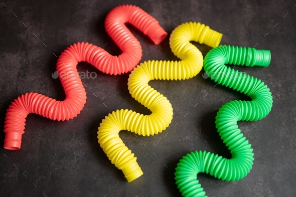 kids anti stress sensory pop tube plastic fidget push toy on a black ...
