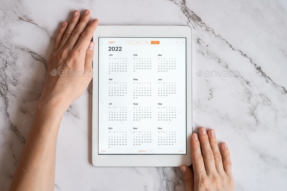 tablet computer with calendar for 2022 year, hands holding. flat lay ...