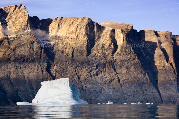 A Russian icebreaker dwarfed by a large iceberg in Franz Joseph Fjord ...